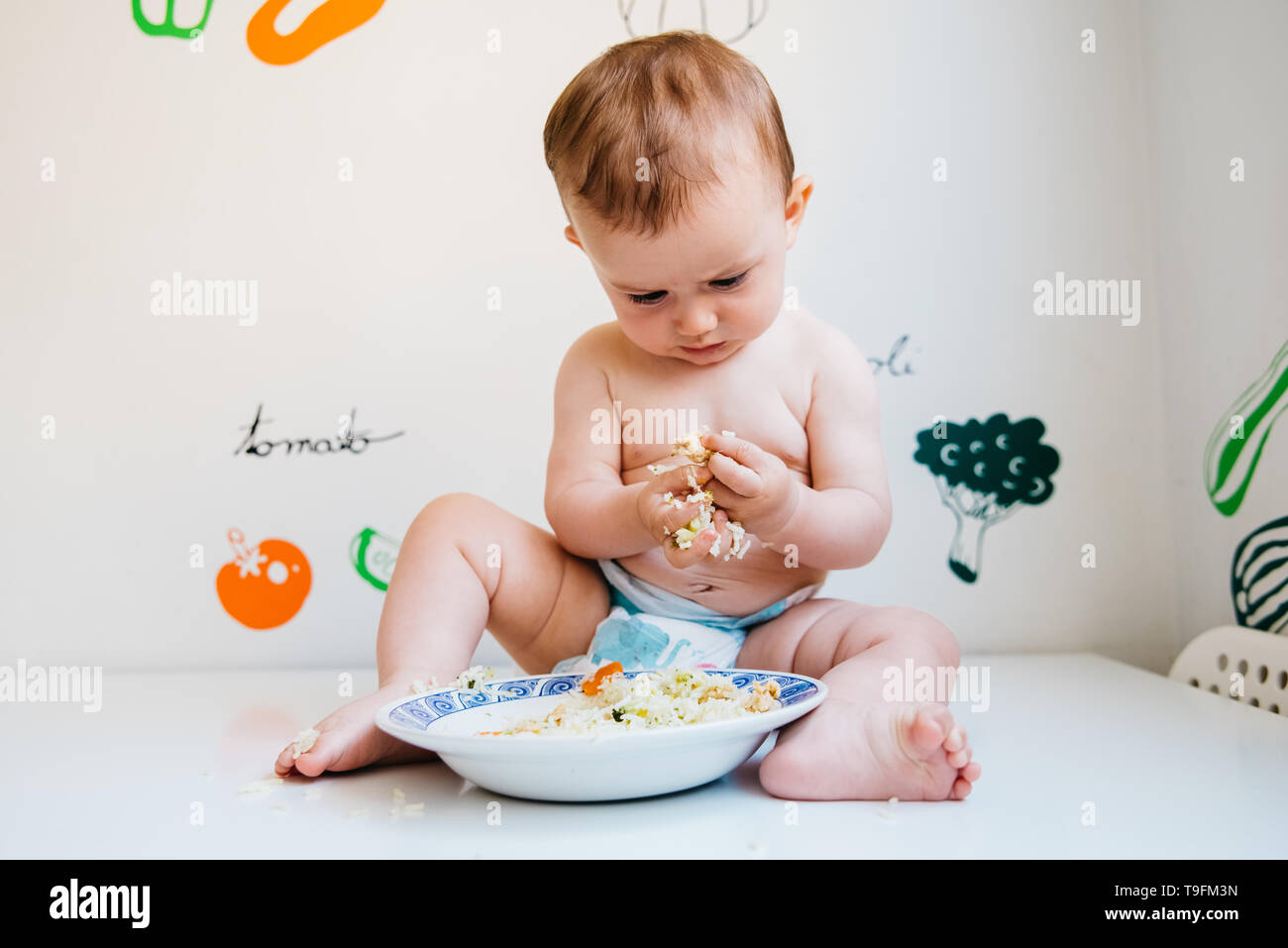 Baby taking handfuls of food to put in his mouth and eat them Stock ...