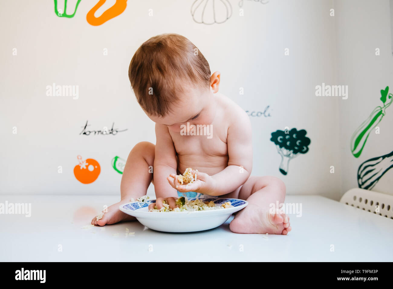 Baby eating by himself learning through the Baby-led Weaning method ...