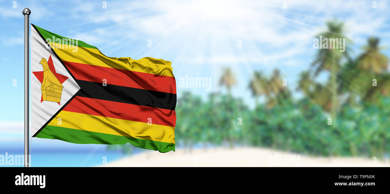 Waving Zimbabwe flag in the sunny blue sky with summer beach background ...