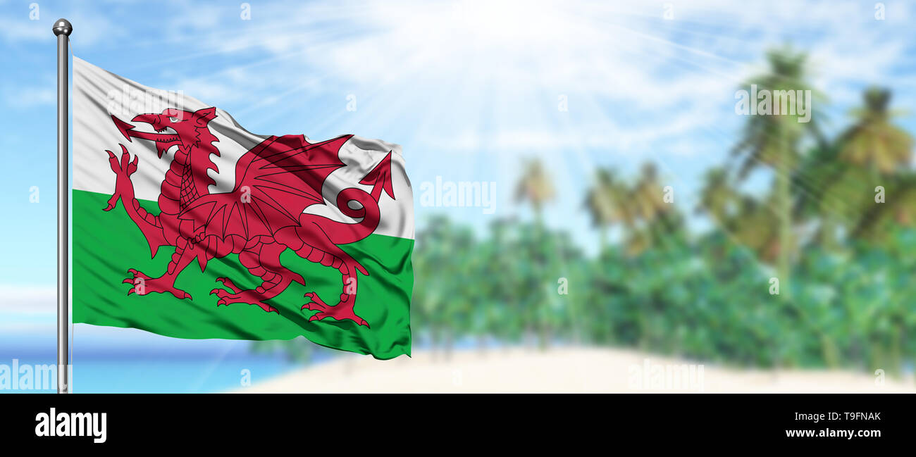 Waving Wales flag in the sunny blue sky with summer beach background ...