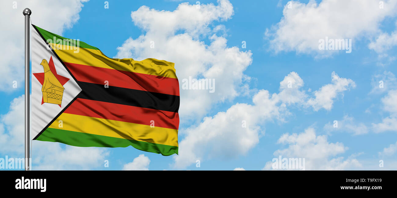 Zimbabwe flag waving in the wind against white cloudy blue sky ...