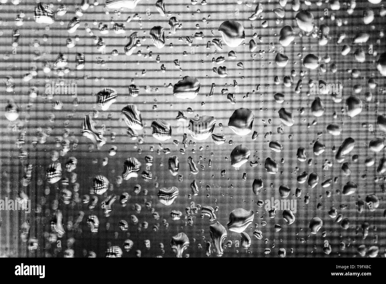 Drops of water on a window screen reveal patterns and designs Stock ...
