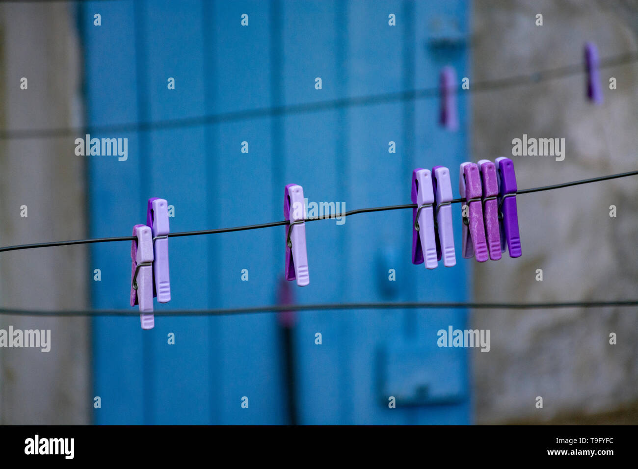 Clothespins on washing rope, hanging outside in small Provencal village ...