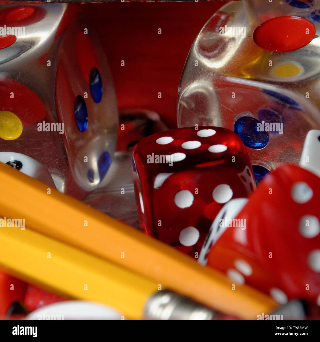 a variety of dice of different sizes and colors with two pencils Stock ...