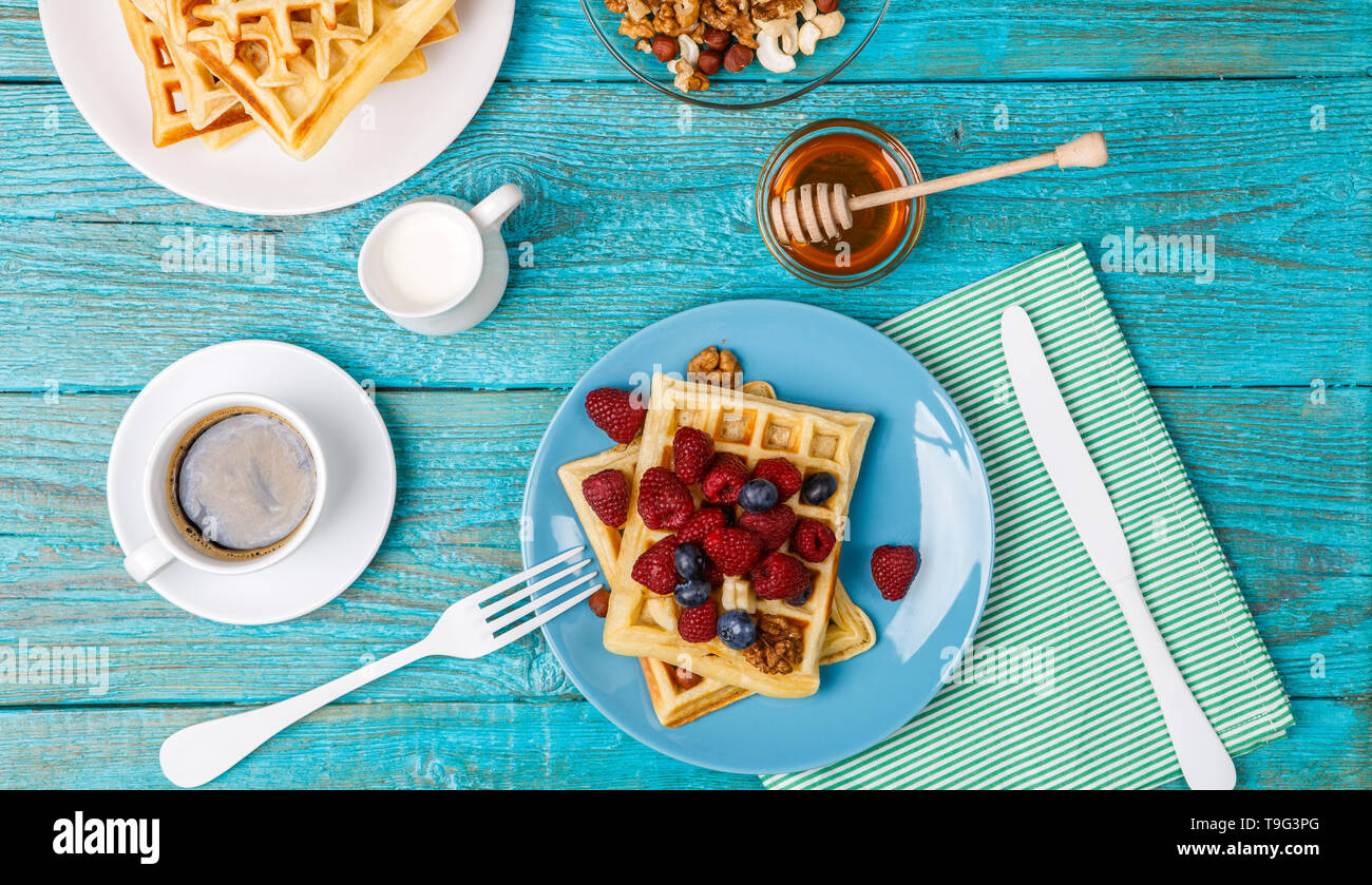 Homemade waffles with raspberries and blueberry, cup of coffee, milk ...