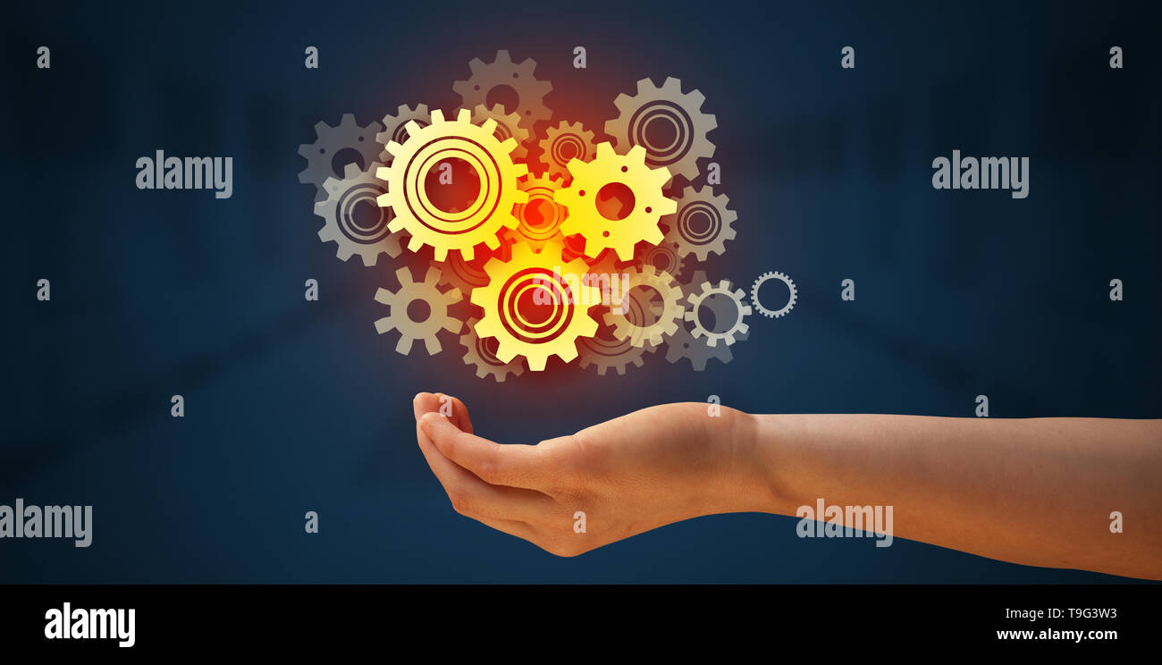 Hand holding gears in his hand Stock Photo - Alamy