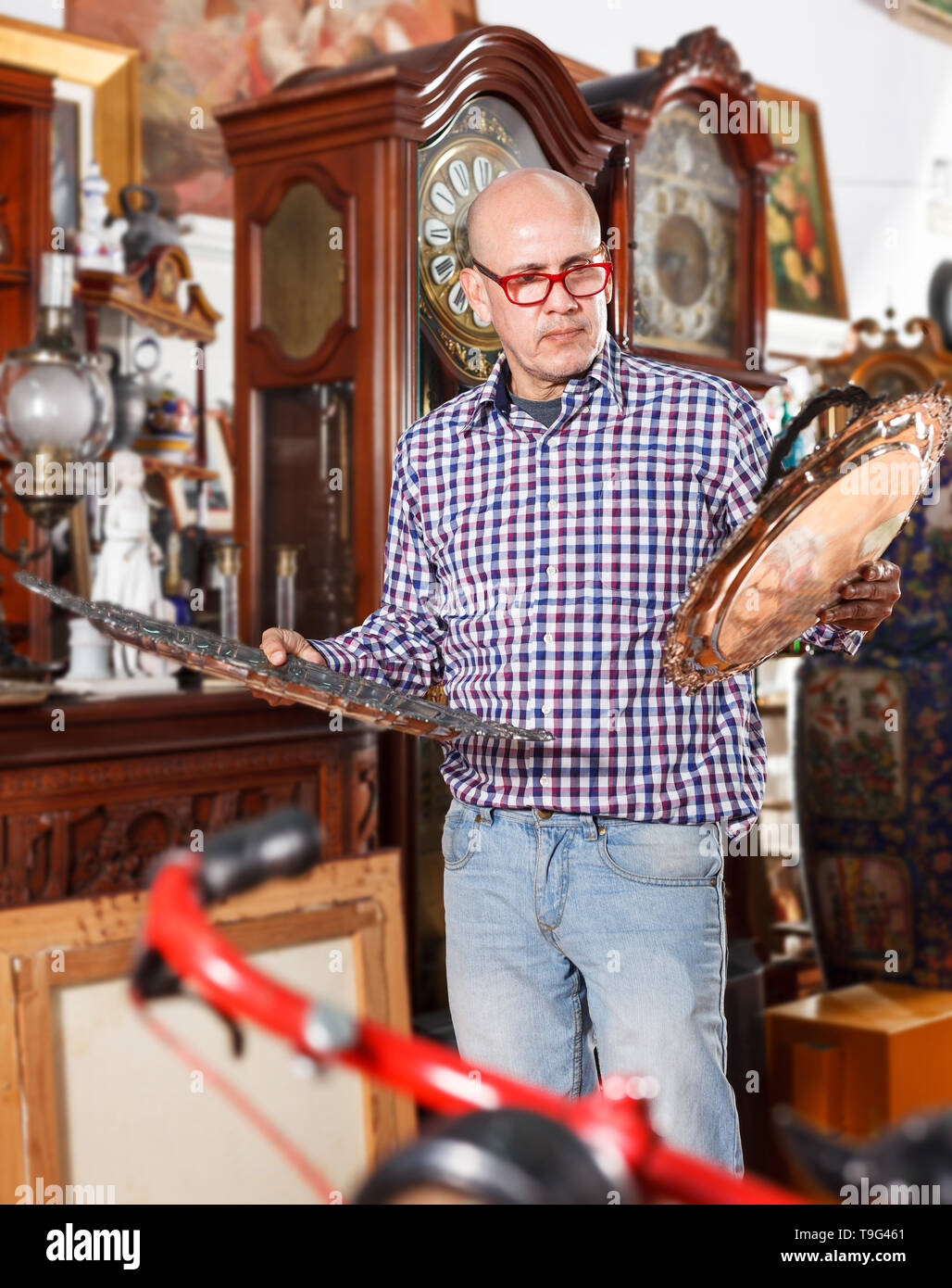 Interested adult male collector of rare items choosing ancient things ...