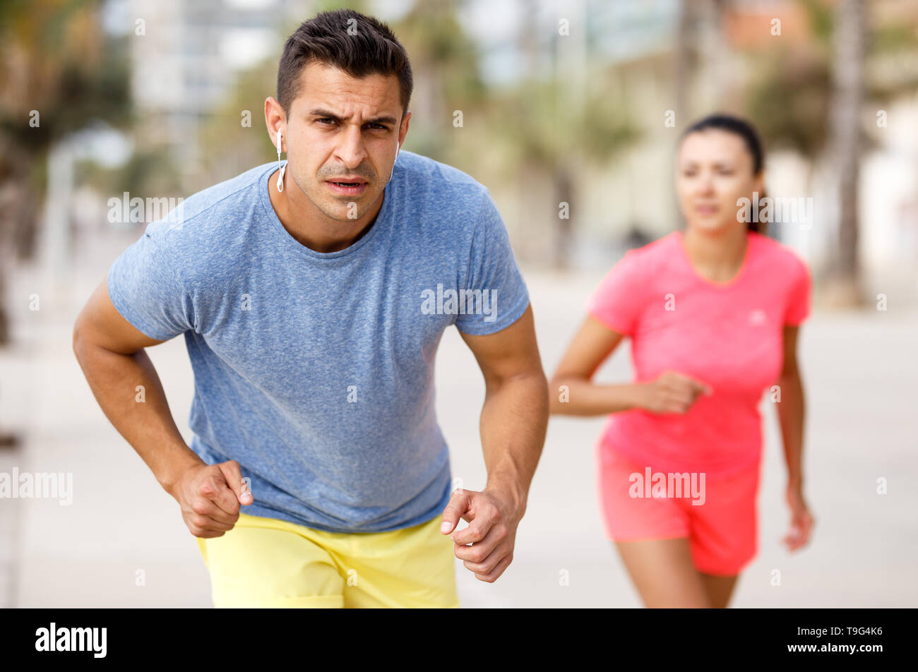 Two active friends running at morning city landscape enjoying healthy ...