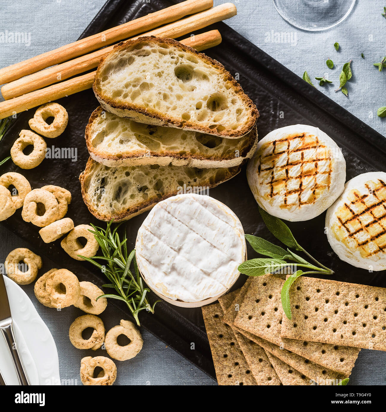 grilled Italian Tomino cheese served on a table with white wine ...