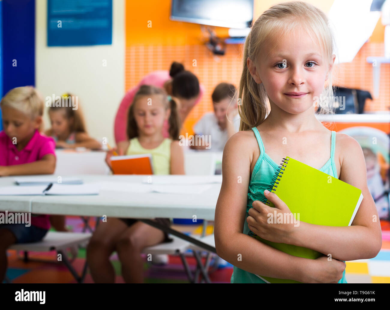 Portrait of joyful smiling little school girl standing in class Stock ...