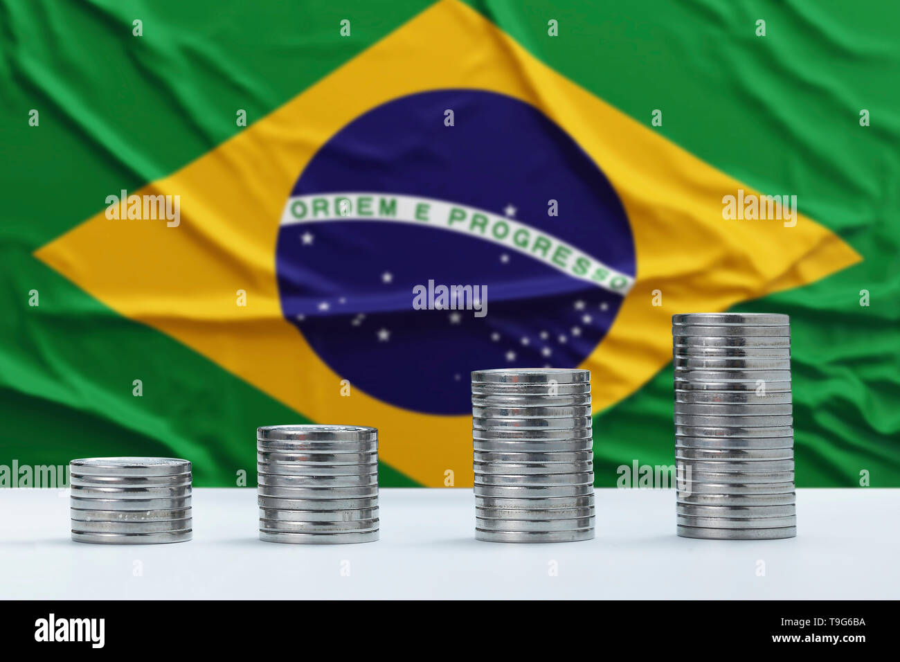 Wrinkled Brazil flag in the background with rows of coins for finance ...
