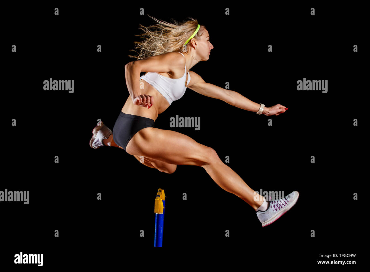 Muscular sportswoman jumping over hurdle on sprint race isolated on ...