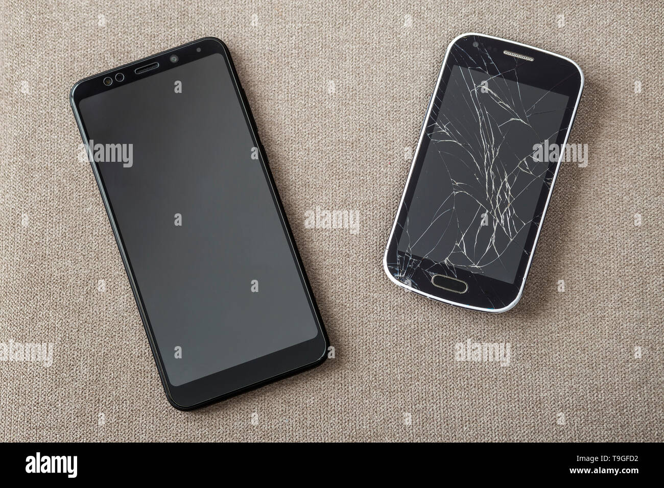 Comparison of two black mobile phones, old cellphone with cracked ...