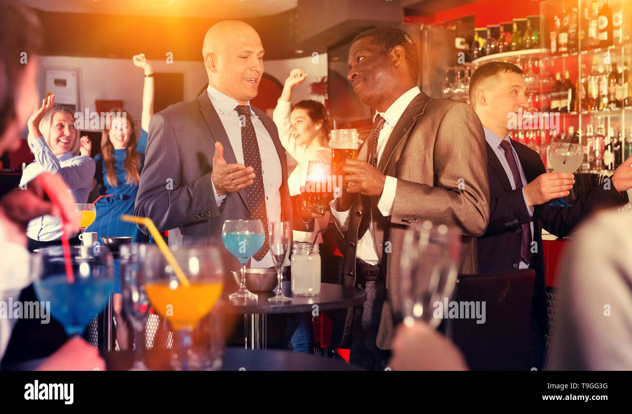 Portrait of African and Caucasian men having fun and talking at ...