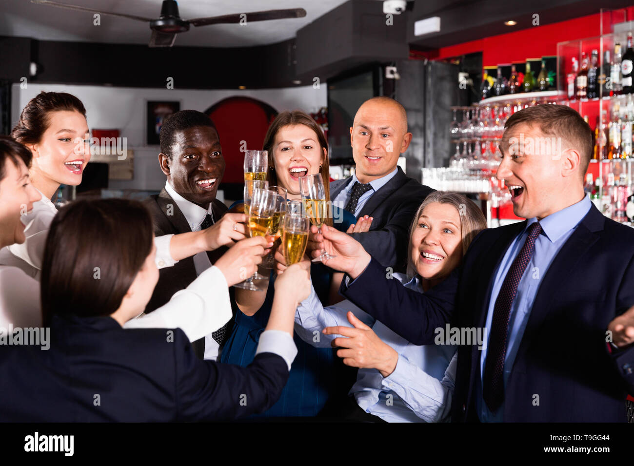 International group of glad smiling businesspeople toasting with ...