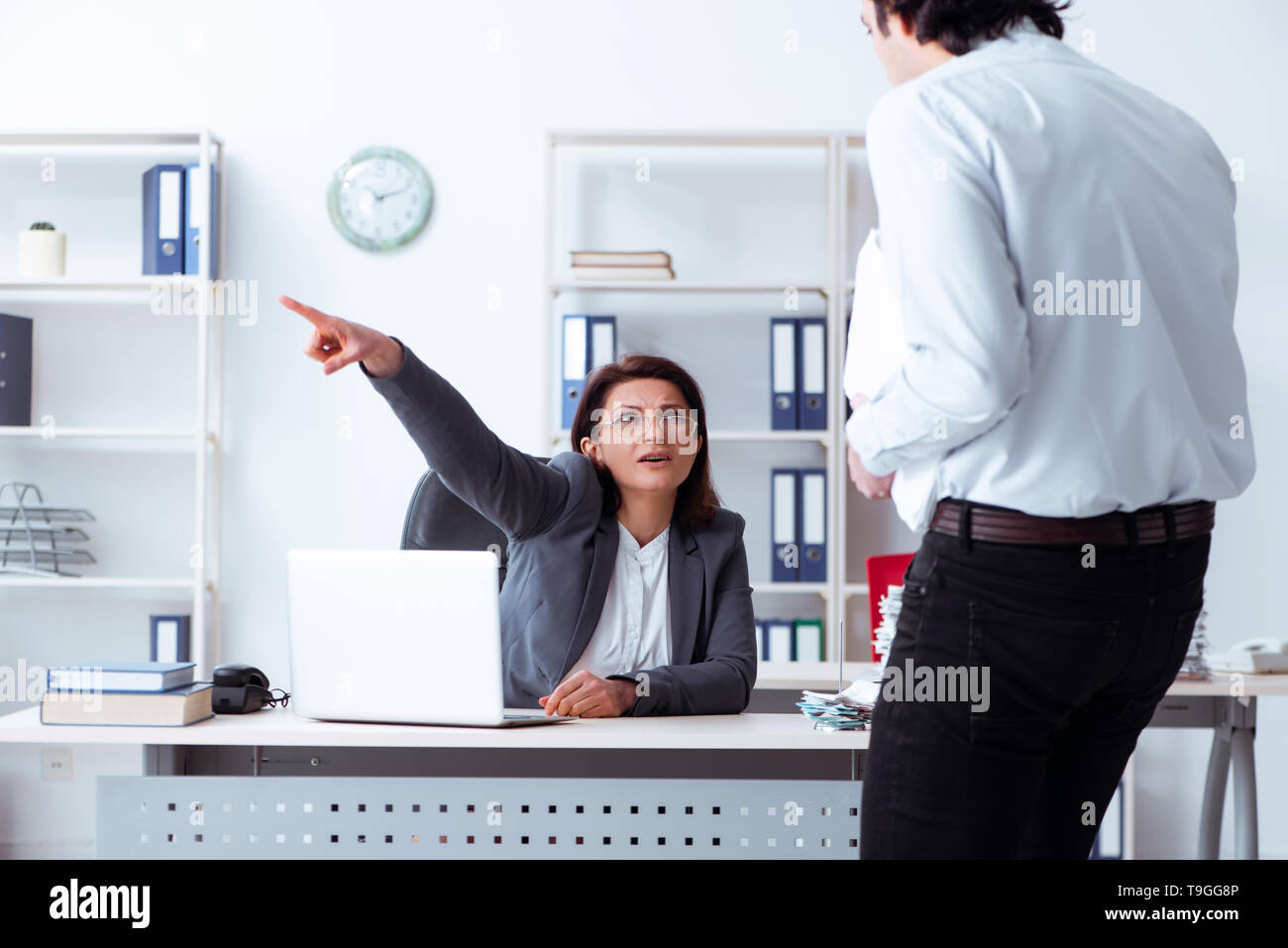 Old female boss and young male employee in the office Stock Photo - Alamy