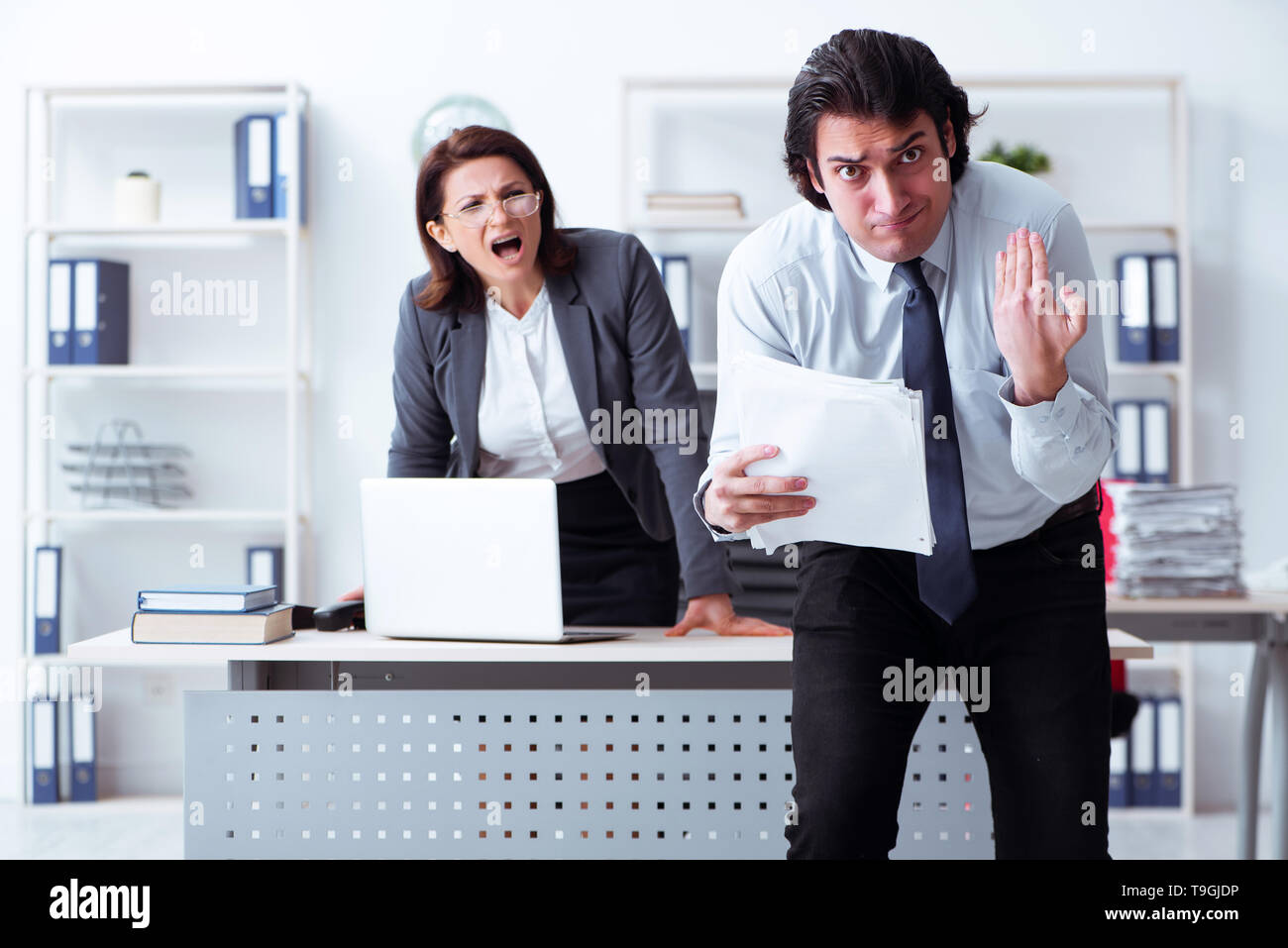 Old female boss and young male employee in the office Stock Photo - Alamy