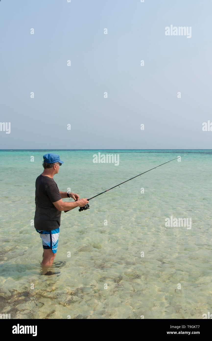 Man fishing off the shore of Ranguana Caye, Belize Stock Photo - Alamy