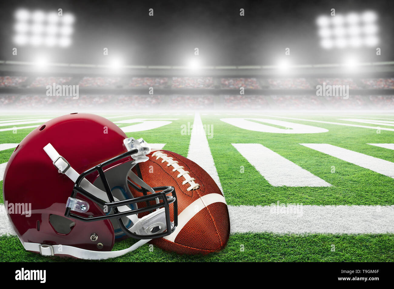 Close up of American football helmet and ball on stadium field with ...