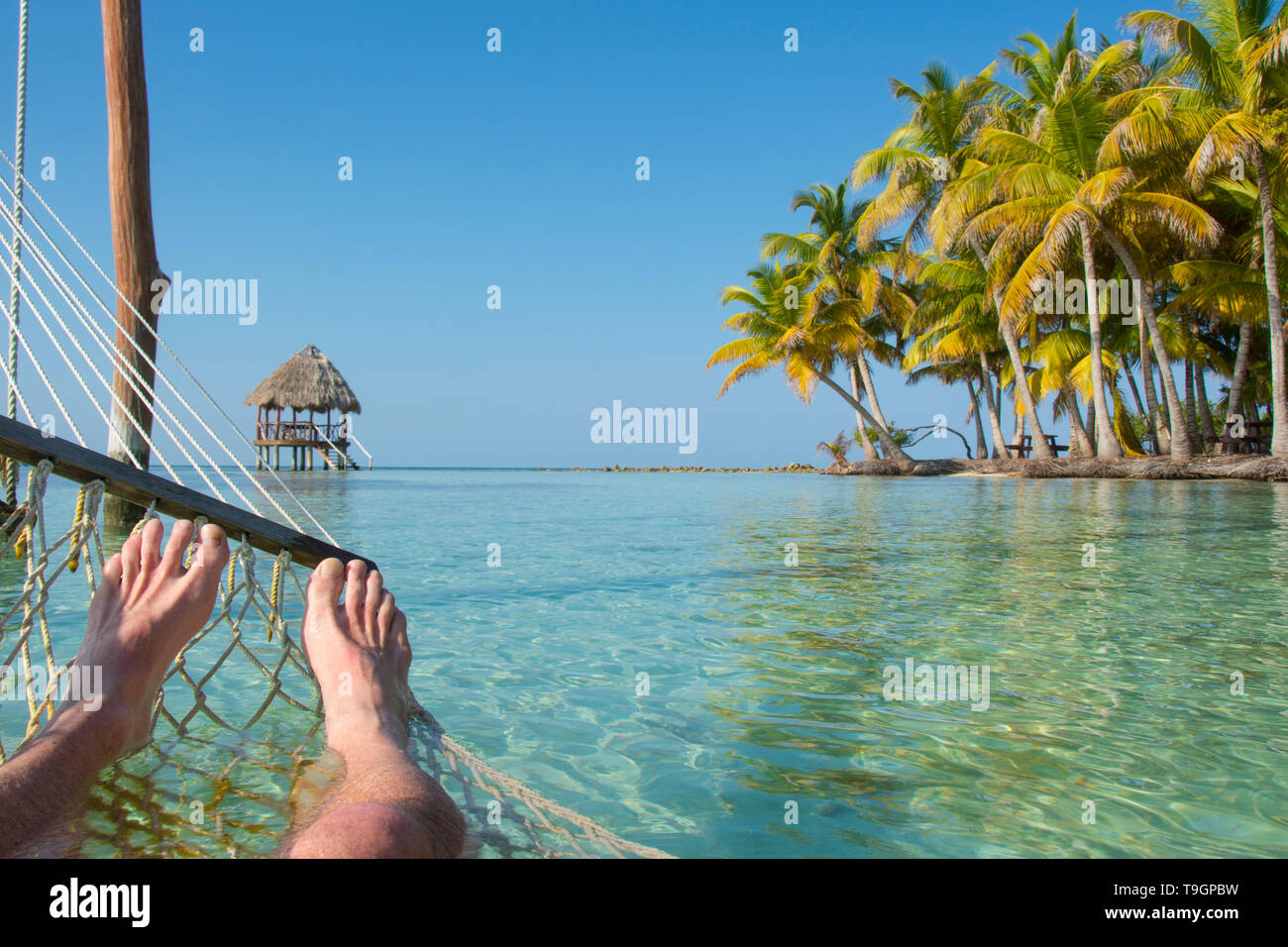 Feet and Hammock in tropical waters and Palapa platforms, North Long ...