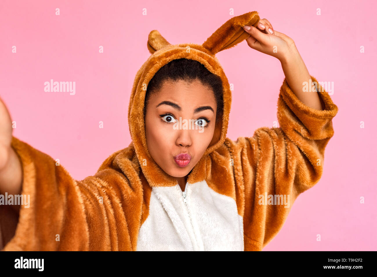 Young Woman In Bunny Kigurumi Standing Isolated On Pink Background