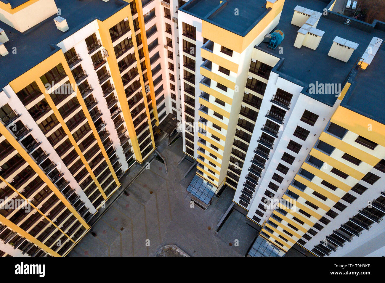 Aerial view of tall apartment building complex. Blue flat roof with ...
