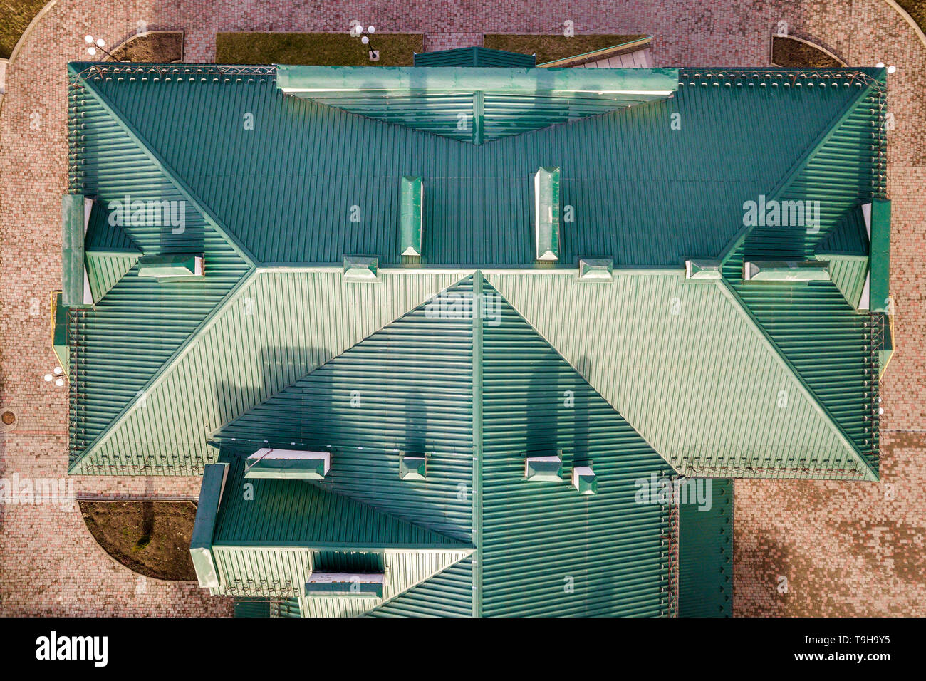 Top aerial view of building green shingle tiled roof with complex ...