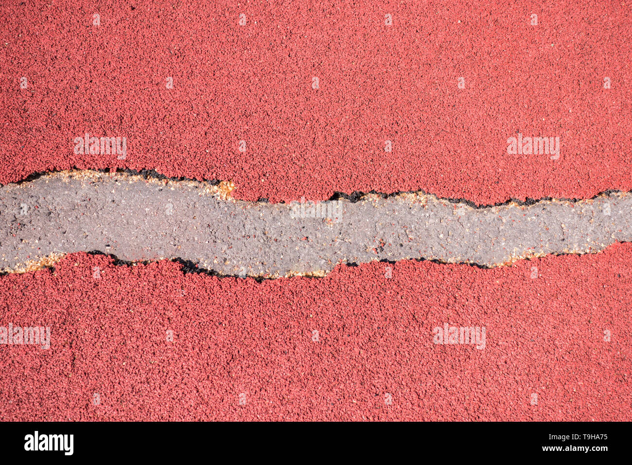 Old torn red rubber crumb cover, treadmill or running track surface ...