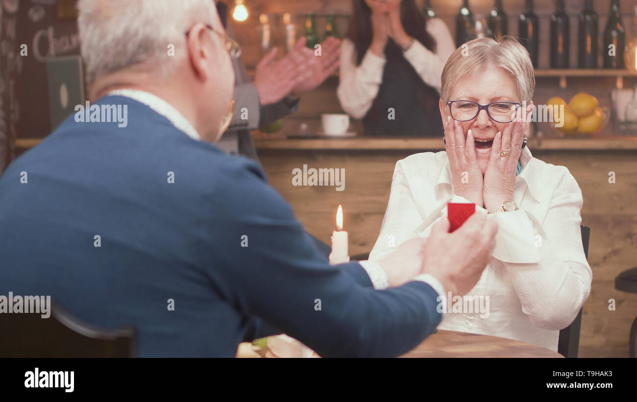 Senior man giving diamond engagement ring in little red box to his ...
