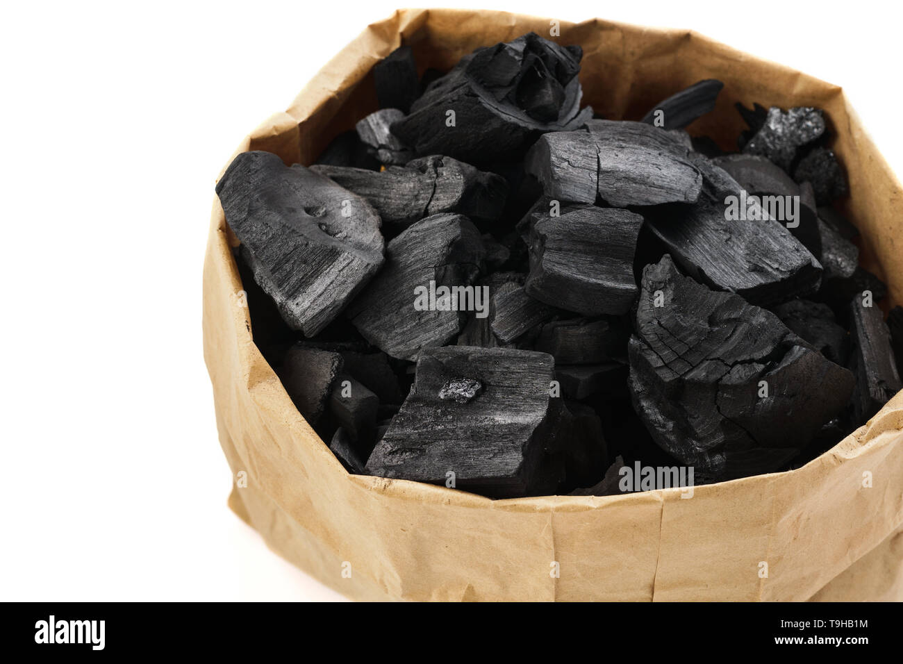 Black charcoal in a paper bag. Charcoal for igniting fire in a grill ...