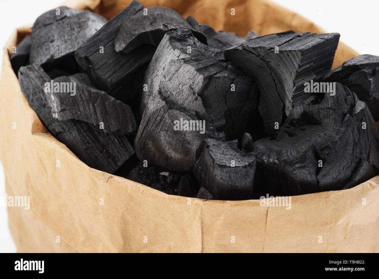 Black charcoal in a paper bag. Charcoal for igniting fire in a grill ...