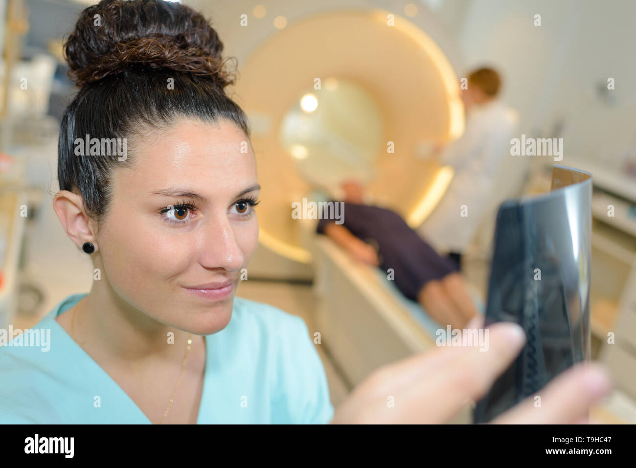 nurse looking at mri film patient on scanner in background Stock Photo ...