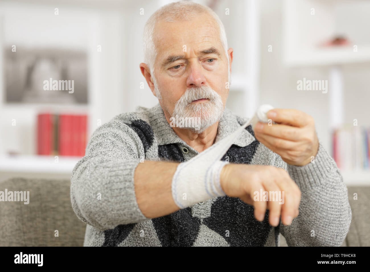senior man is bandaging his arm Stock Photo - Alamy