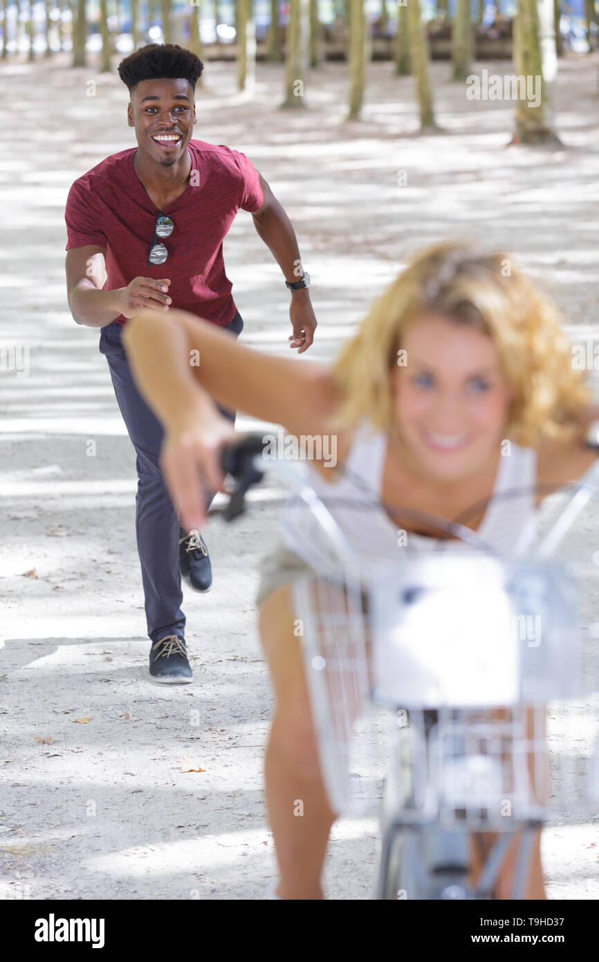 man playfully chasing woman on bicycle Stock Photo - Alamy