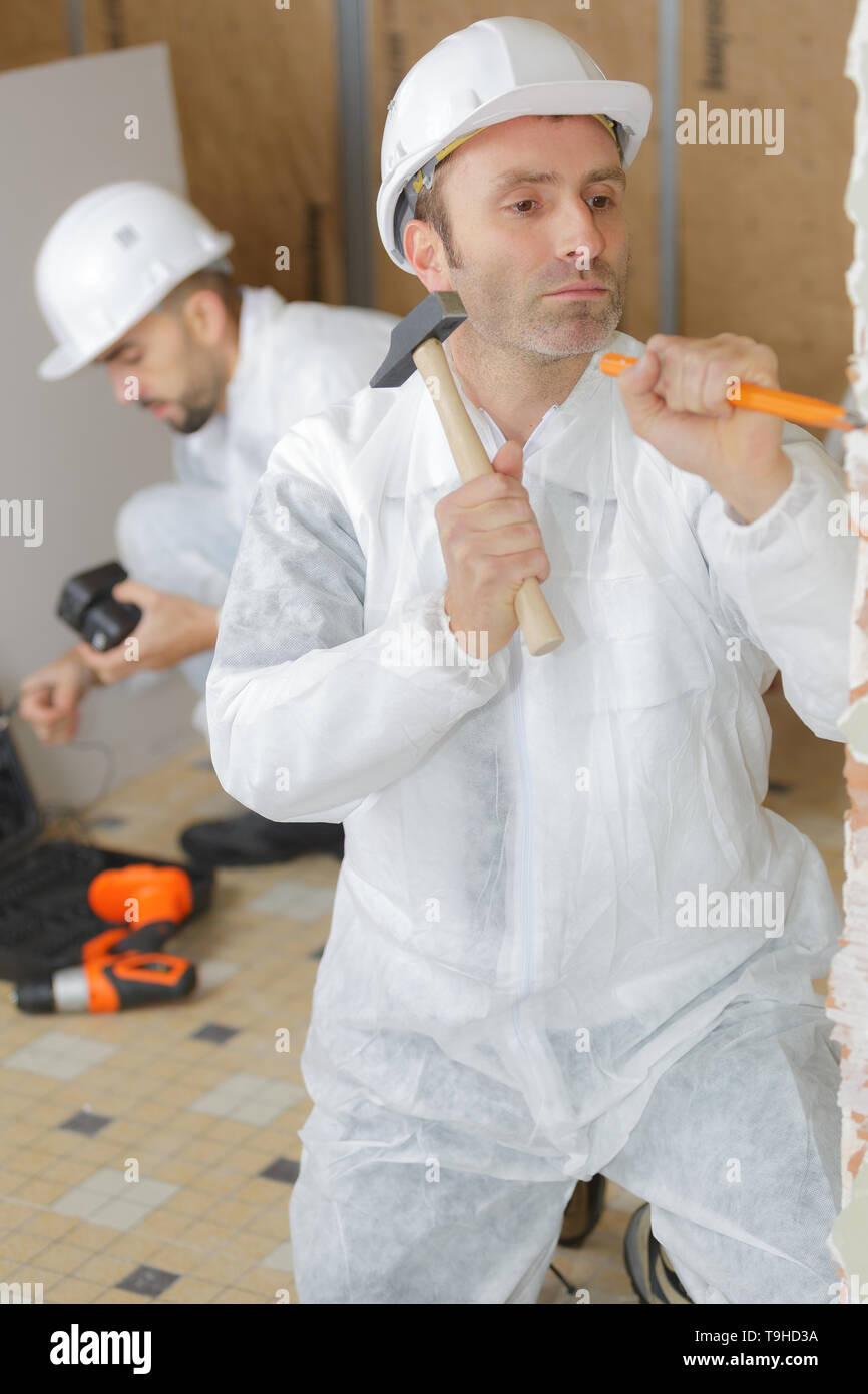 worker demolishing building at construction site Stock Photo - Alamy