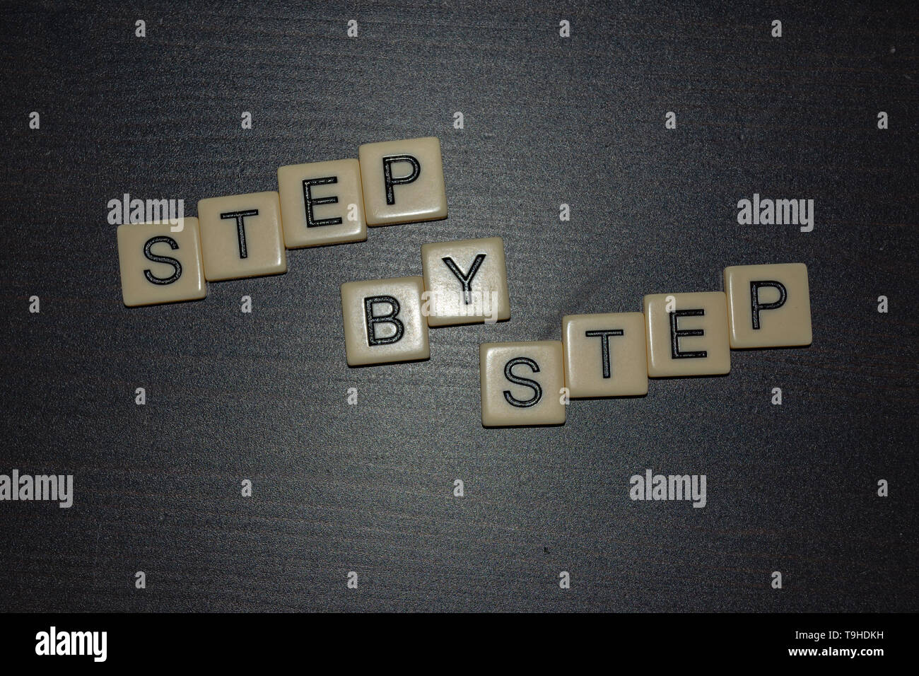 Tile letters step by step progression on a black background. Concept ...
