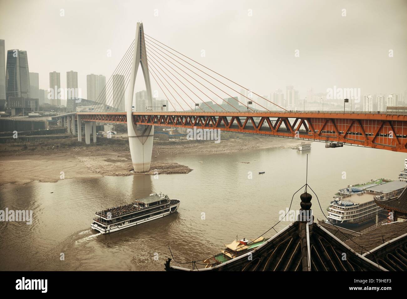 Boat pass below bridge with city urban architecture in Chongqing, China ...