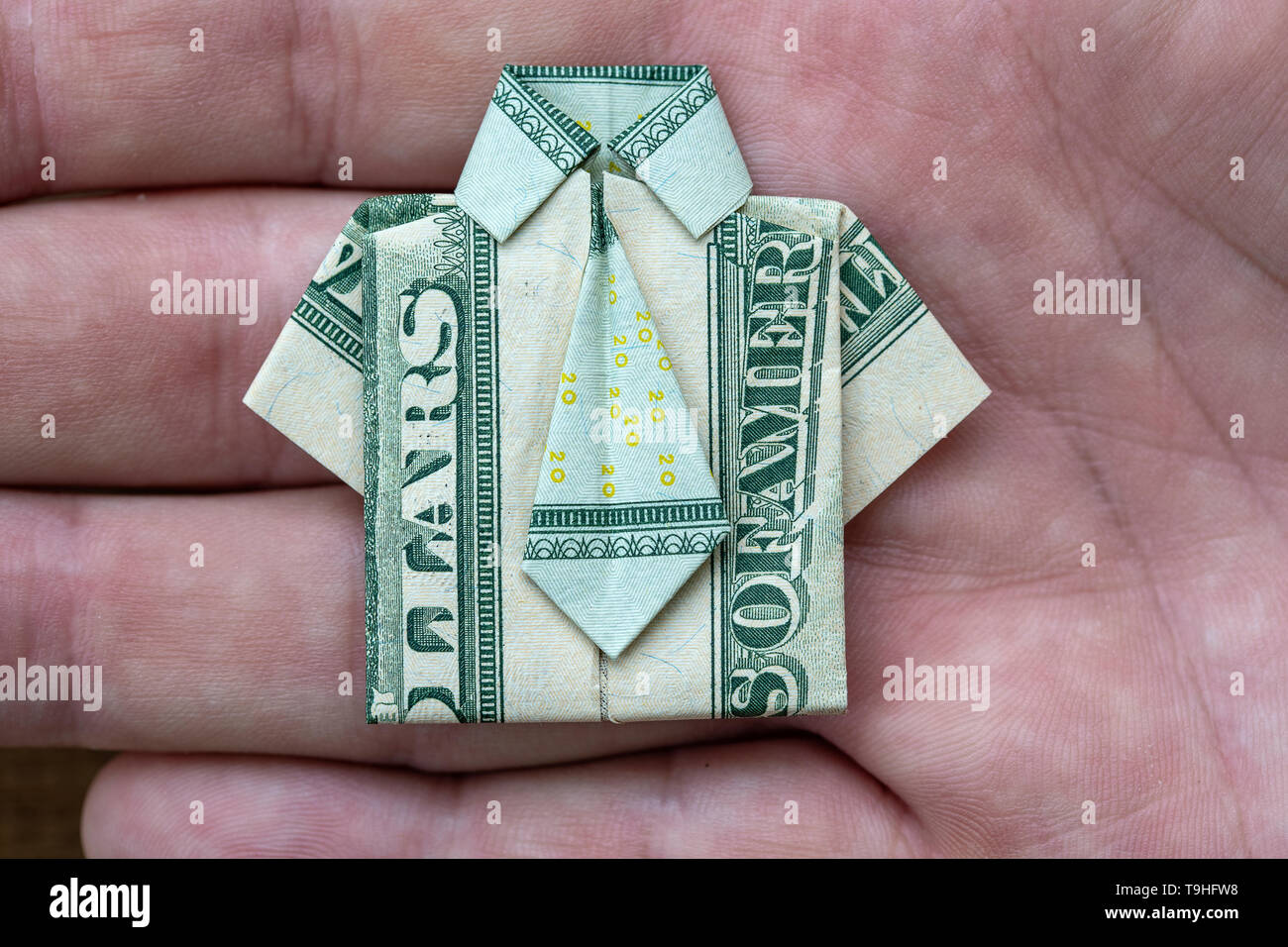 Origami shirt made of dollar banknote on hand background. Close up ...