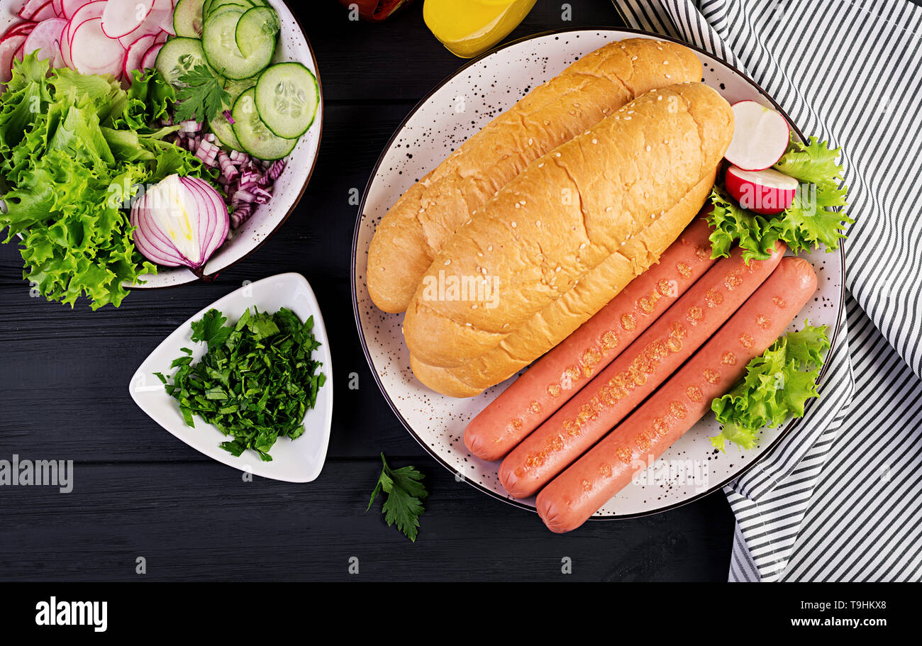 Ingredients for hot dog with sausage, cucumber, radish and lettuce on ...