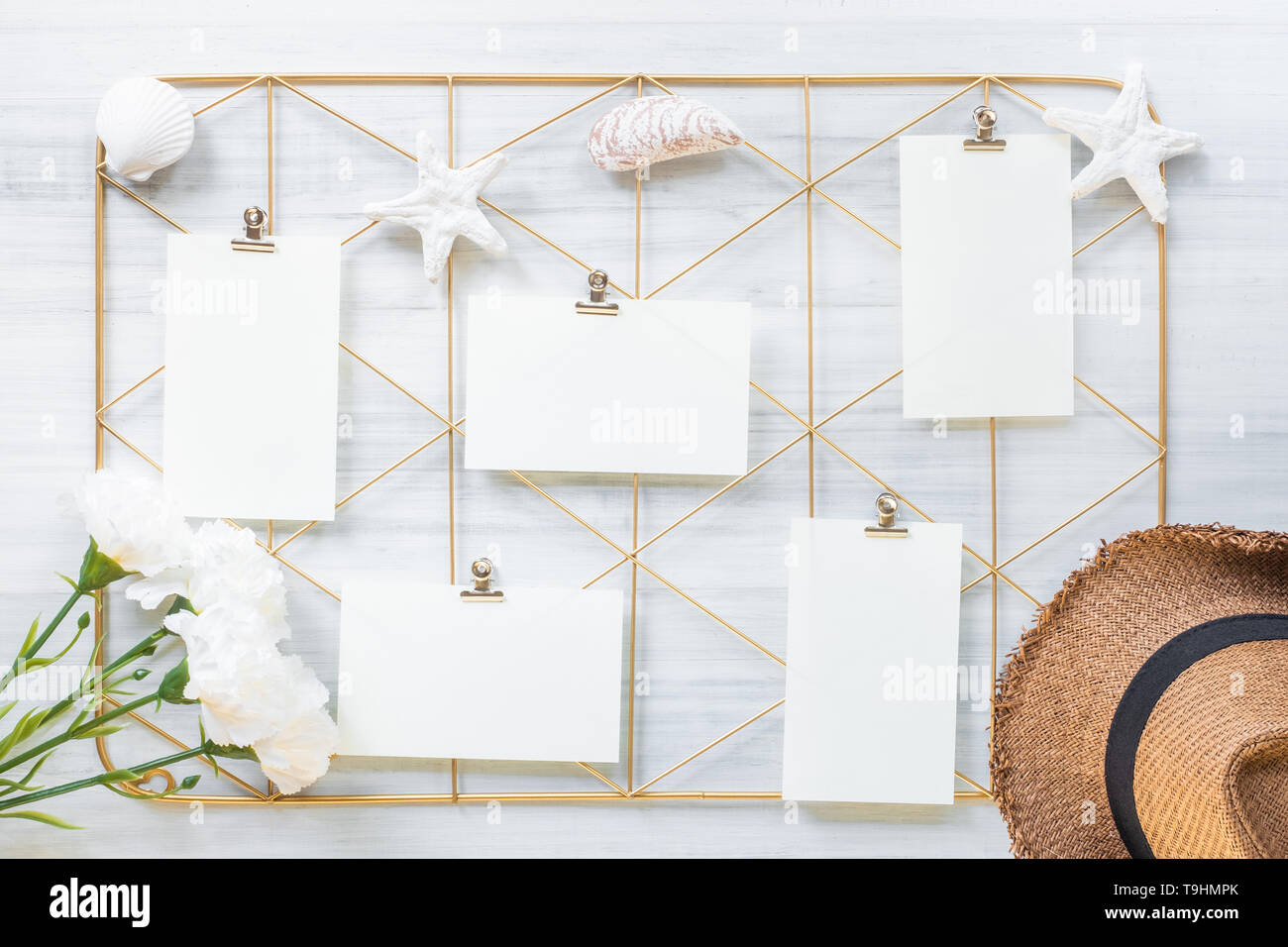 Top view set of note pad clip frame and summer hat with flower on white ...