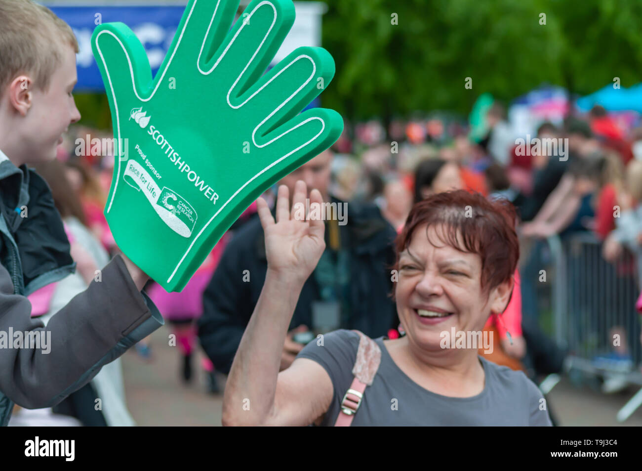 Glasgow, Scotland, UK. 19th May, 2019. A female runner gives a high ...