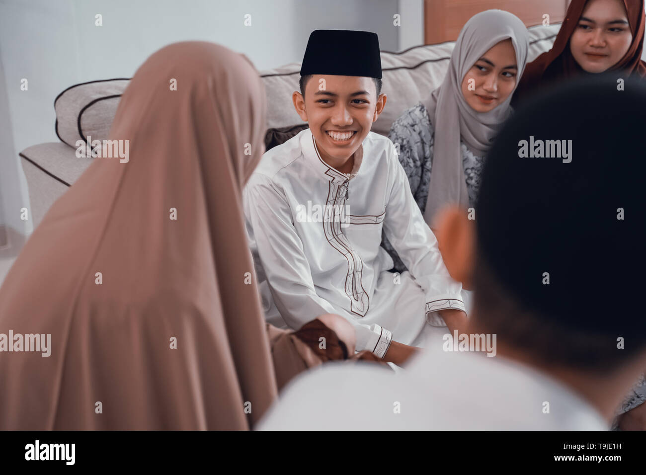 asian muslim people talk to each other at home together in livingroom ...