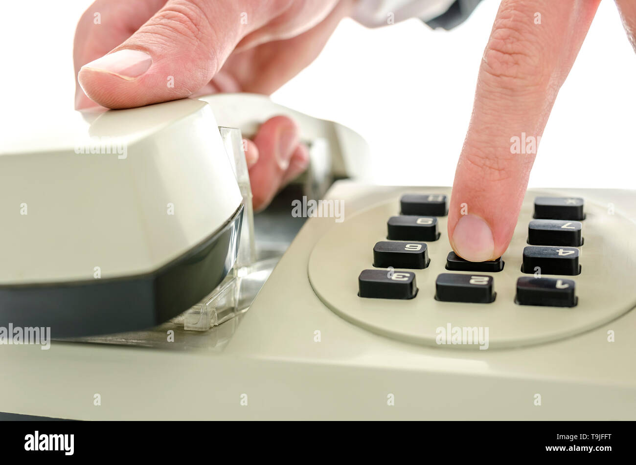 Detail of dialing a number on and old telephone. Isolated over white ...