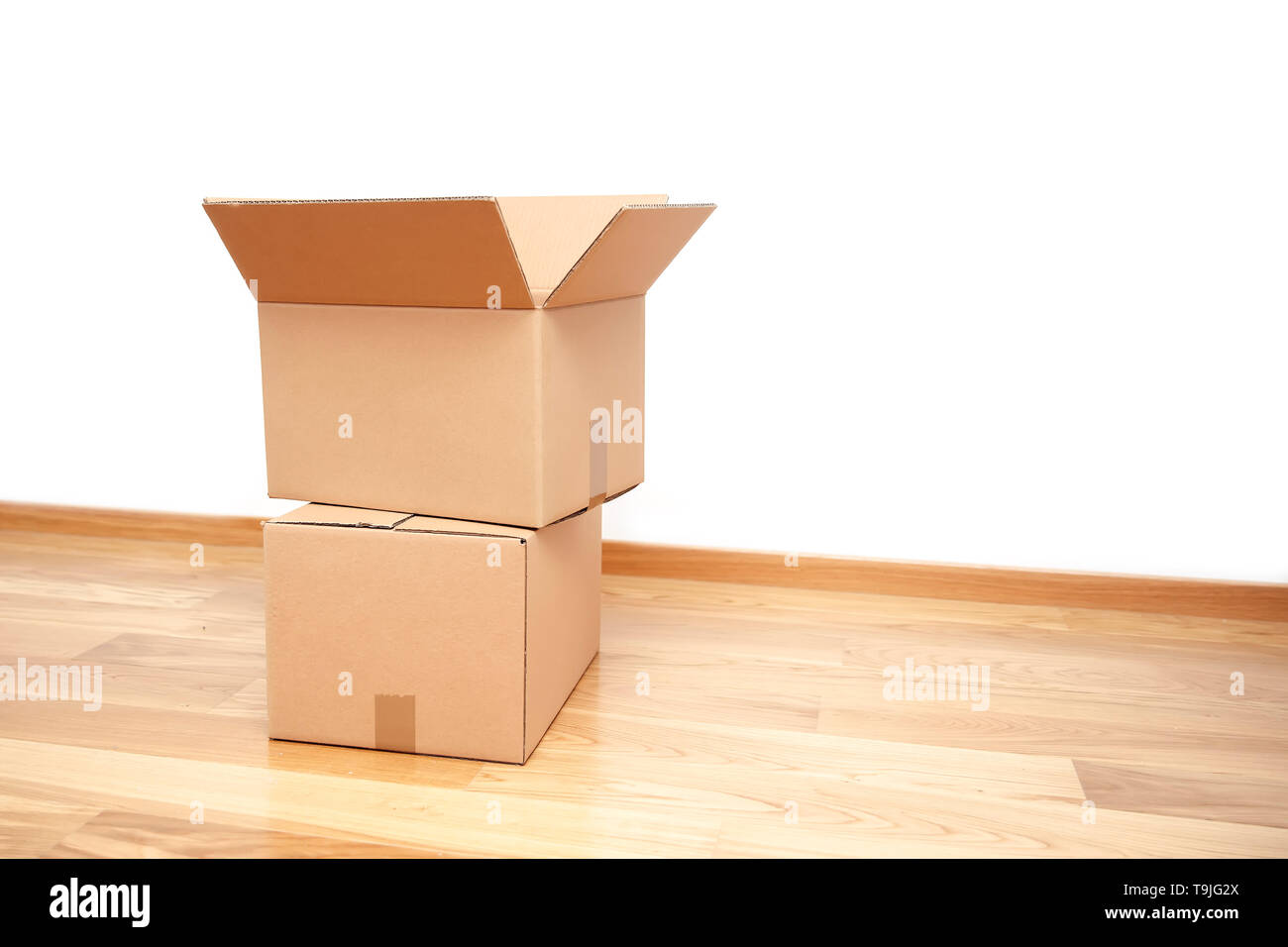 Open cardboard box on the floor in empty room, ready for transport ...