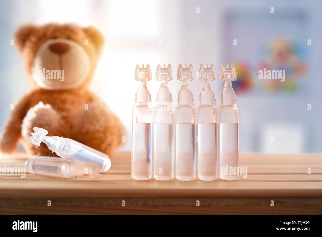 Eye drops for pediatric eye and nose cleaning on wood table with teddy ...