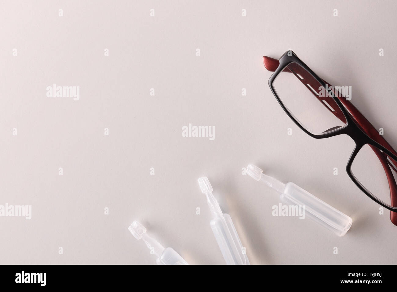 several pipettes of eye drops spread on white table. Horizontal ...