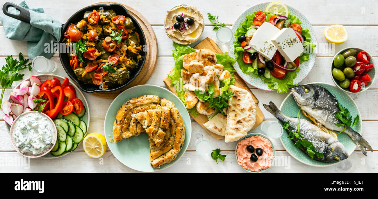 Selection of traditional greek food - salad, meze, pie, fish, tzatziki ...