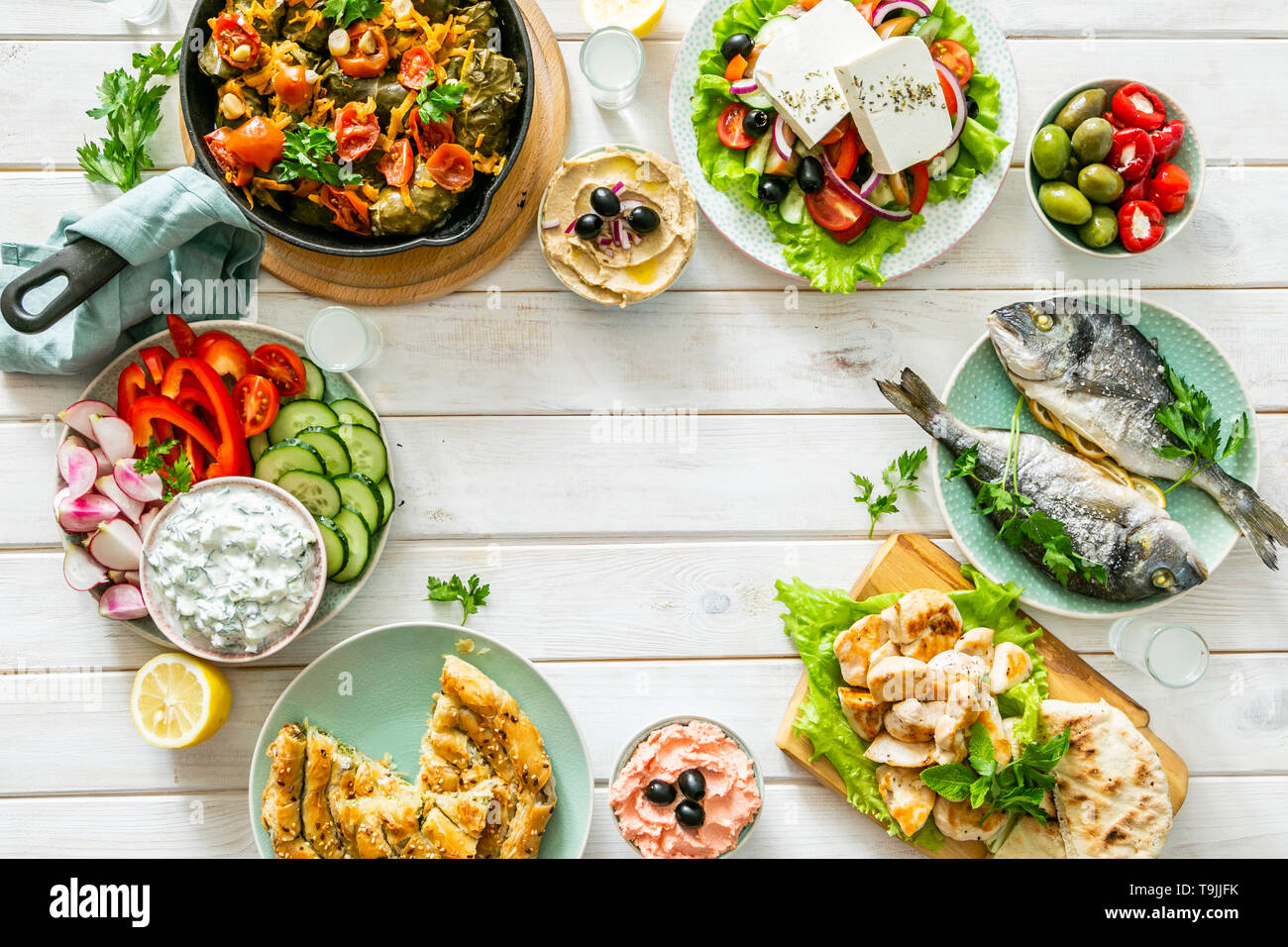 Selection of traditional greek food - salad, meze, pie, fish, tzatziki ...