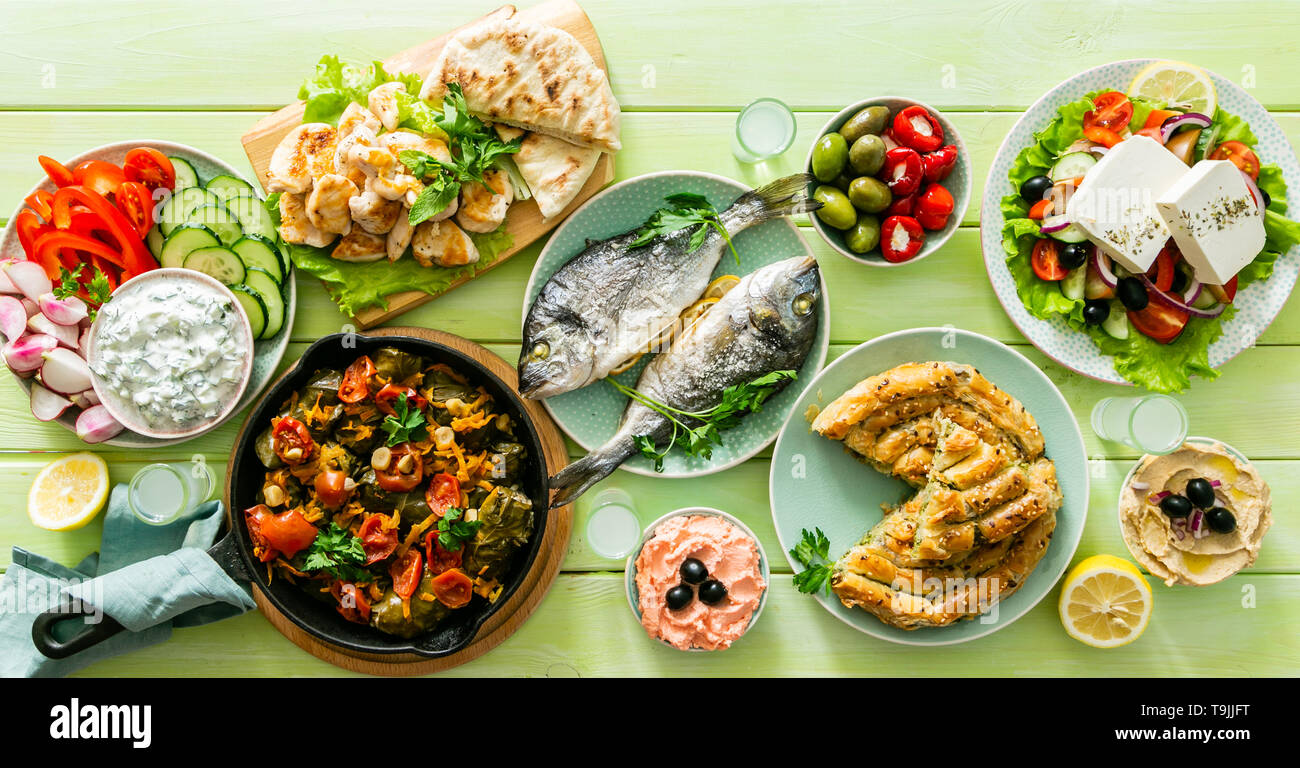 Selection of traditional greek food - salad, meze, pie, fish, tzatziki ...