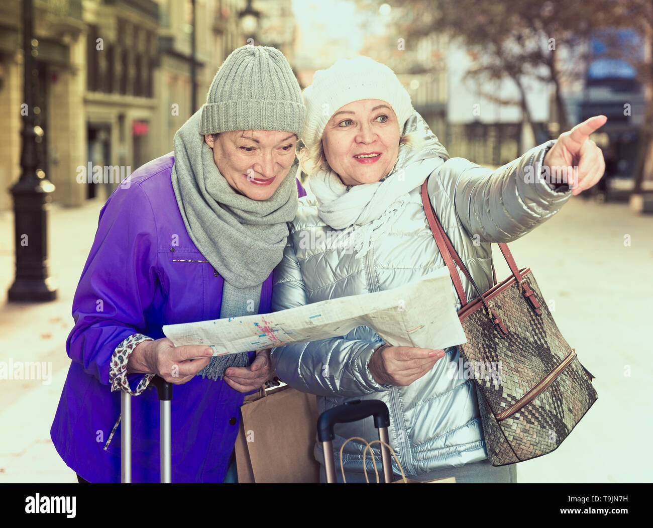 Senior woman with female friend traveling together looking for ...